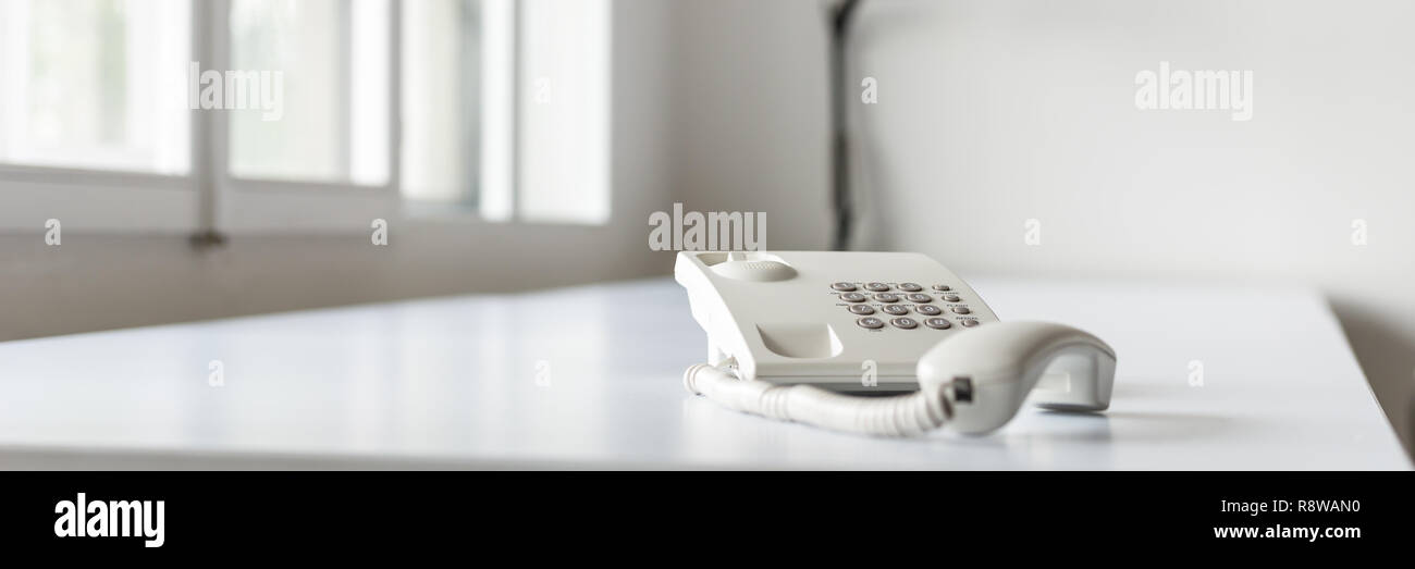Wide view image of white landline telephone with handset off line on ...