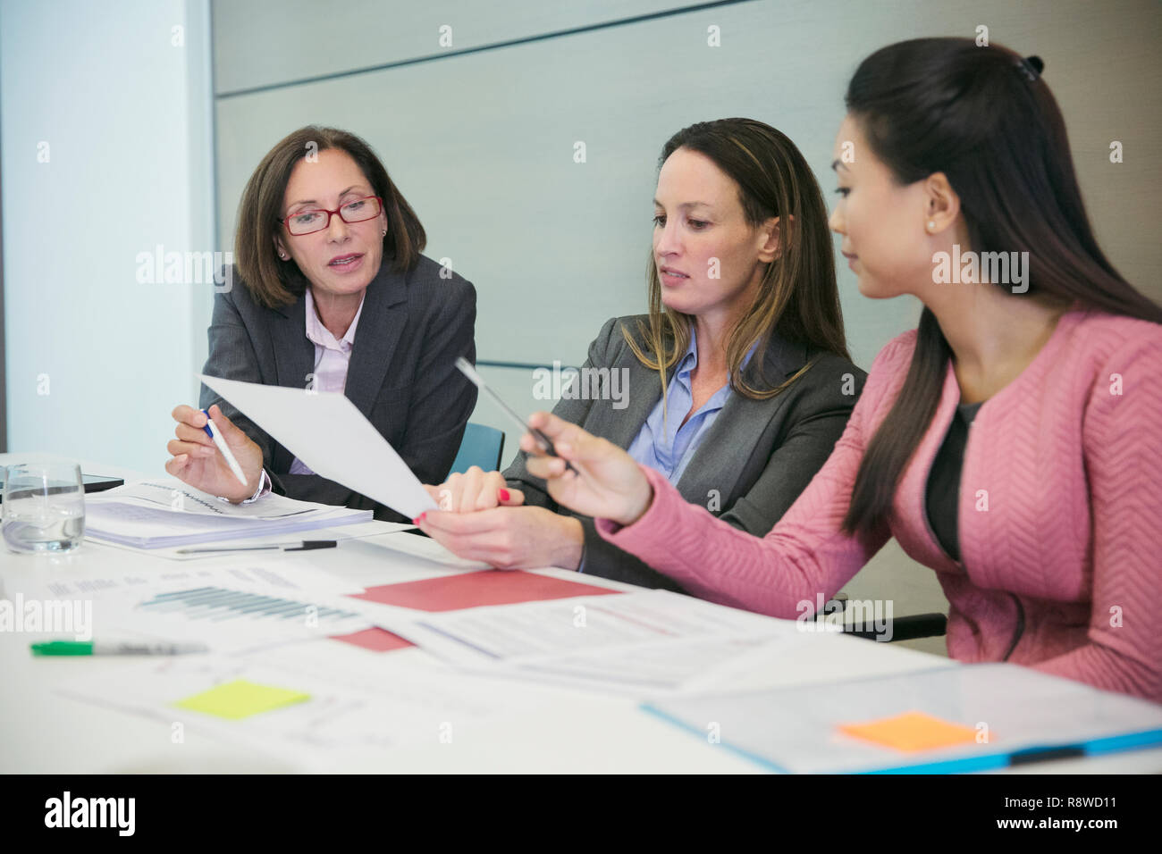 Businesswomen discussing paperwork in conference room meeting Stock ...