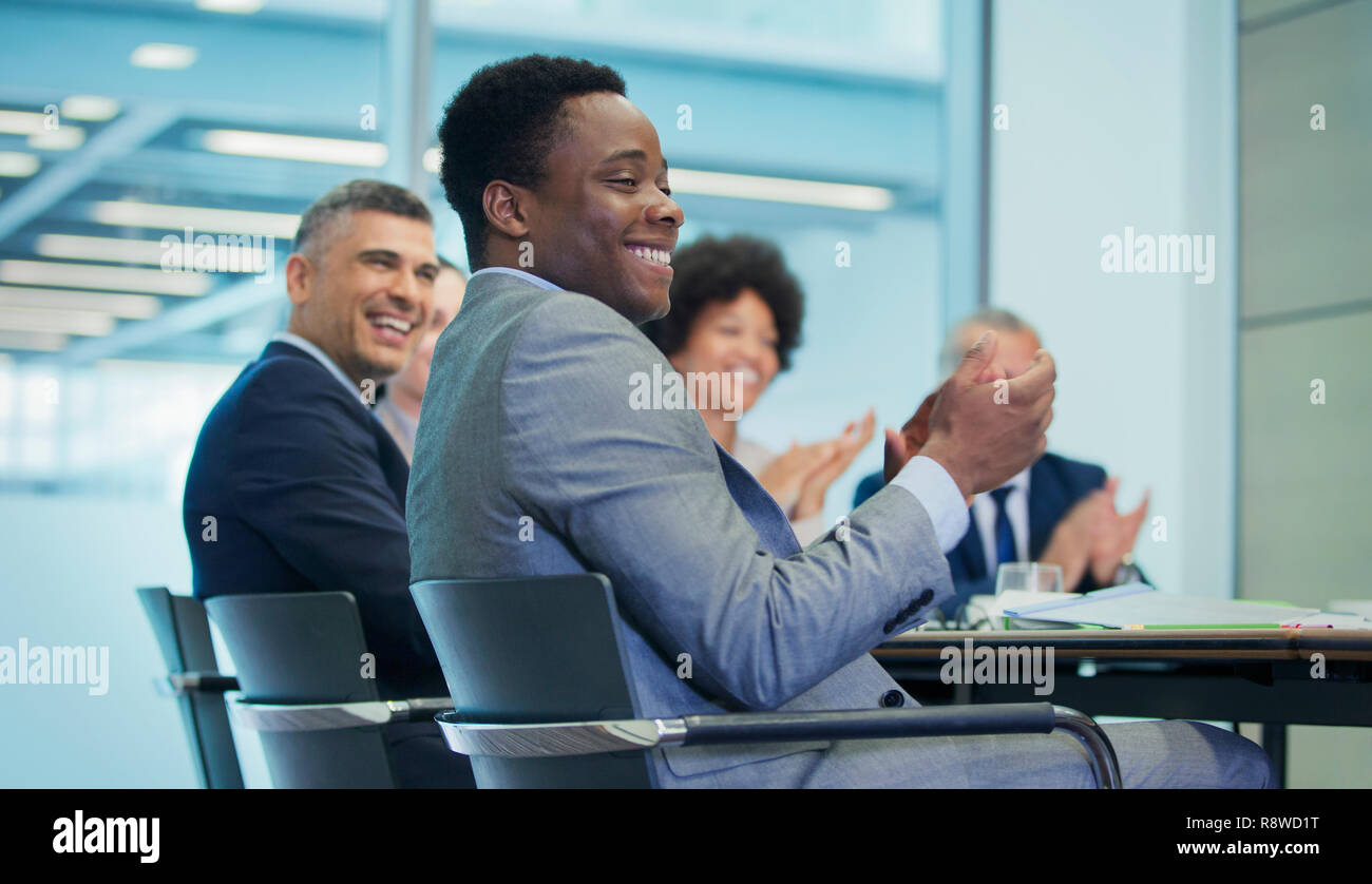 Smiling businessman clapping in conference room meeting Stock Photo - Alamy