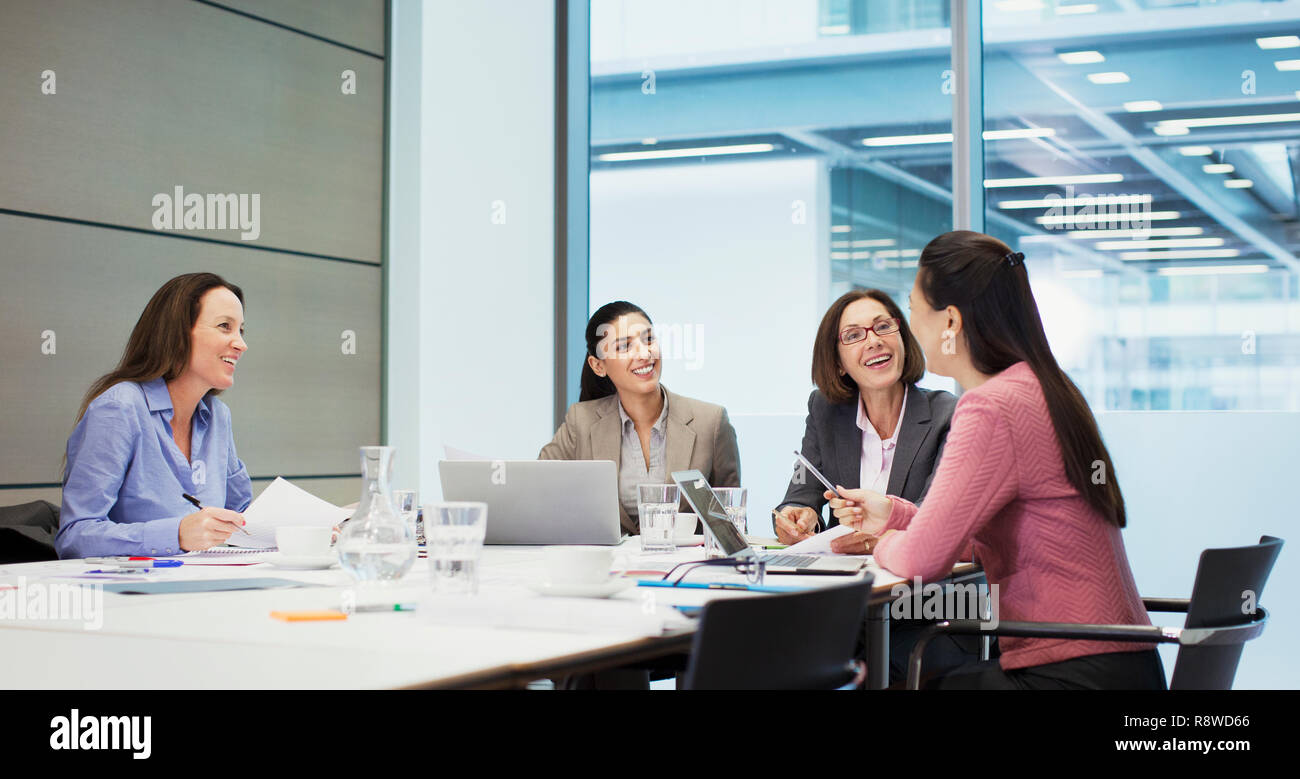 Happy businesswomen talking in conference room meeting Stock Photo - Alamy