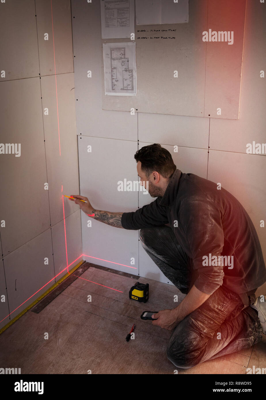 Construction worker using laser measuring tool Stock Photo - Alamy