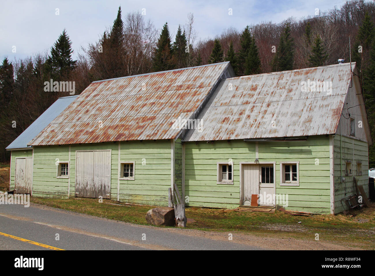 Attached green barns with sheds and rusted roofs Stock Photo - Alamy