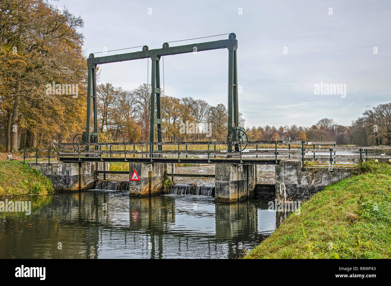 Small concrete barrage with a pedestrian bridge across the Berkel river ...