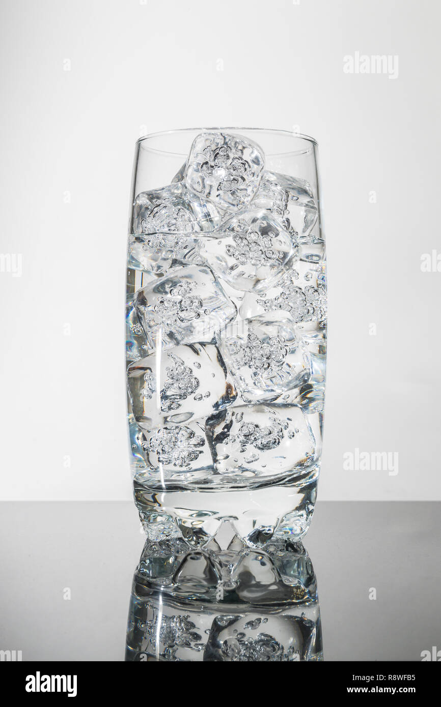 ice cubes and clear liquid in glass tumbler on shiny tabletop Stock ...
