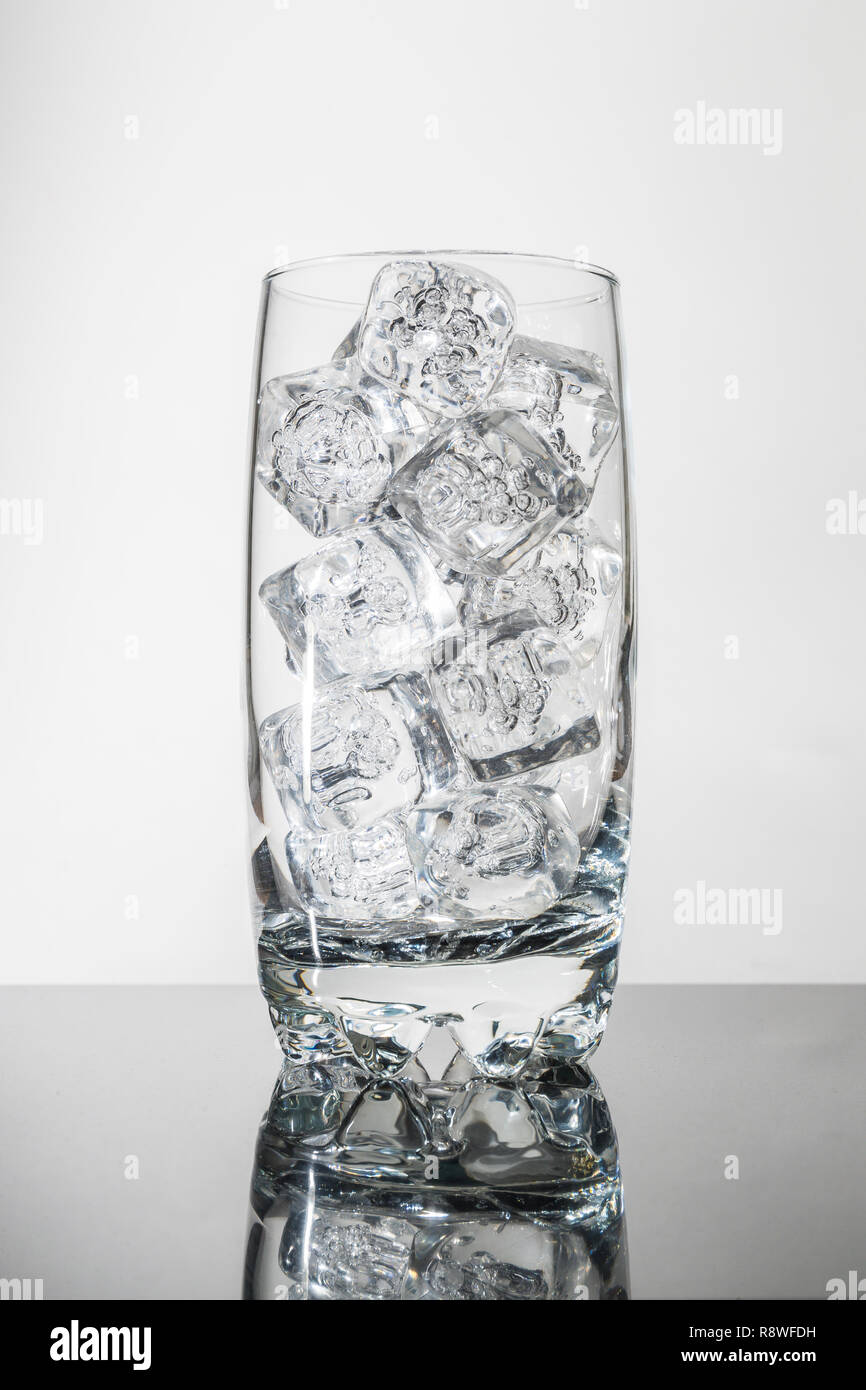 ice cubes in glass tumbler on shiny tabletop Stock Photo - Alamy