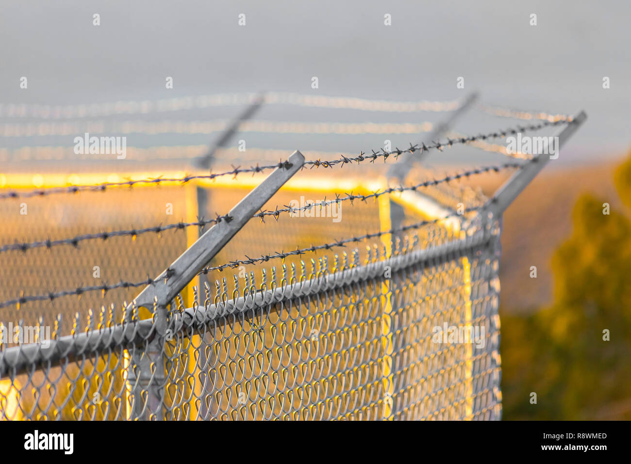 Barbed wire fence surrounding a water tank on hill Stock Photo - Alamy