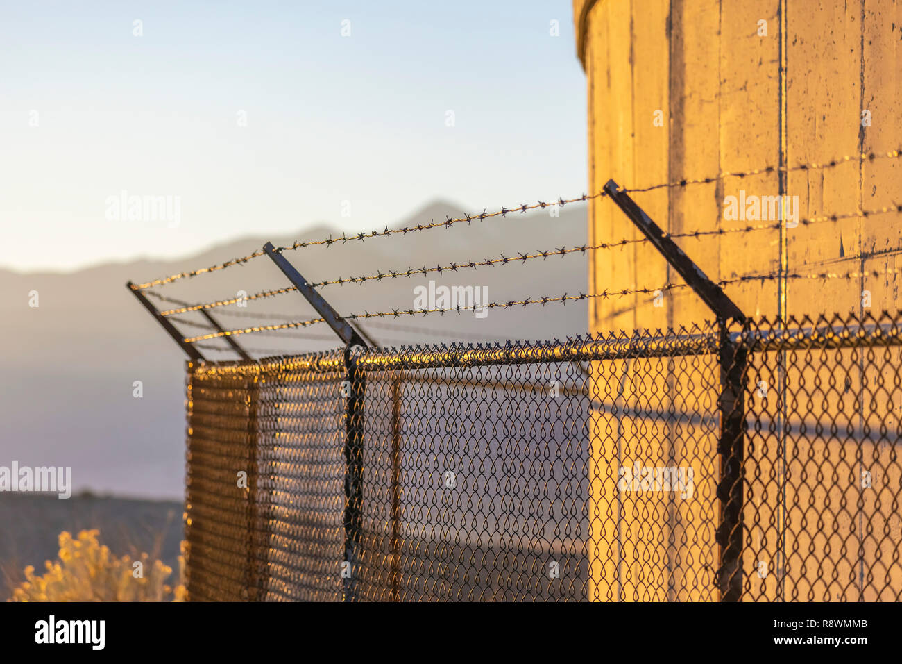 Concrete water tank on hilltop with barbed wire Stock Photo - Alamy