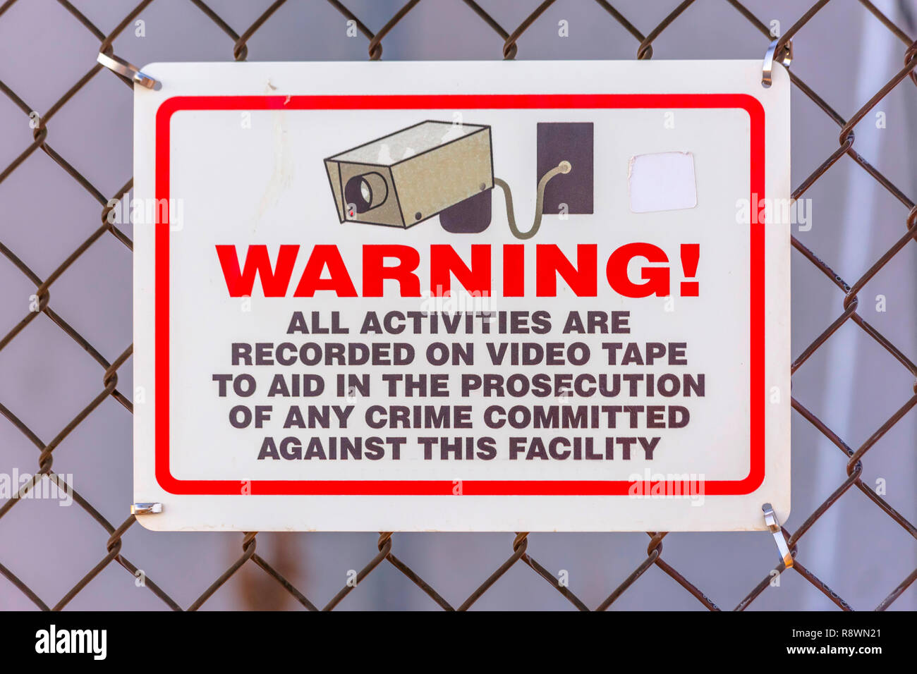 Warning security camera sign on a chain link fence Stock Photo - Alamy
