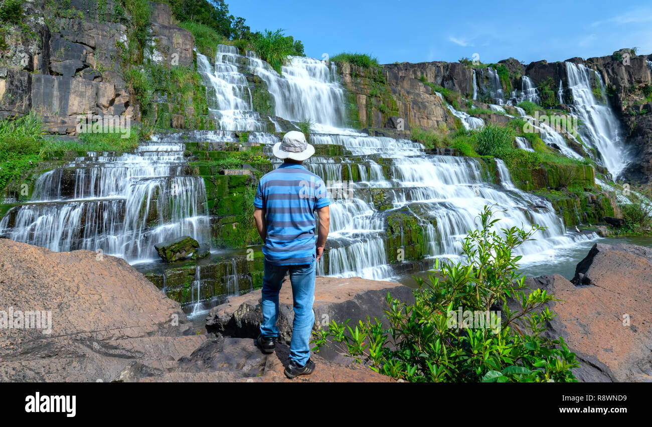 Traveler Man watching beautiful waterfall majestic scenery as a way to ...