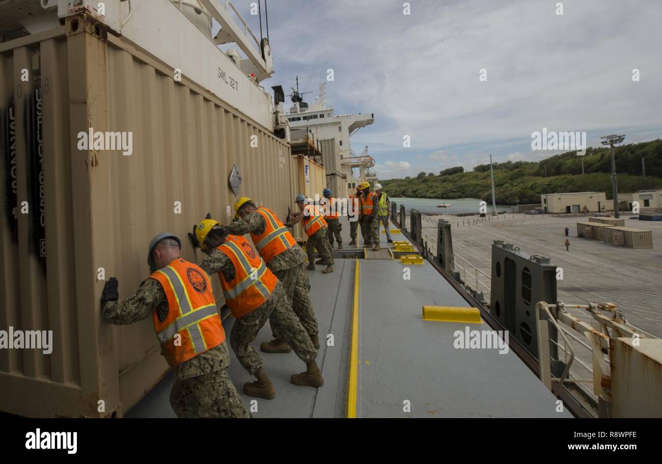 Sailors assigned to Navy Cargo Handling Battalion 1 (NCHB1) guide an ...