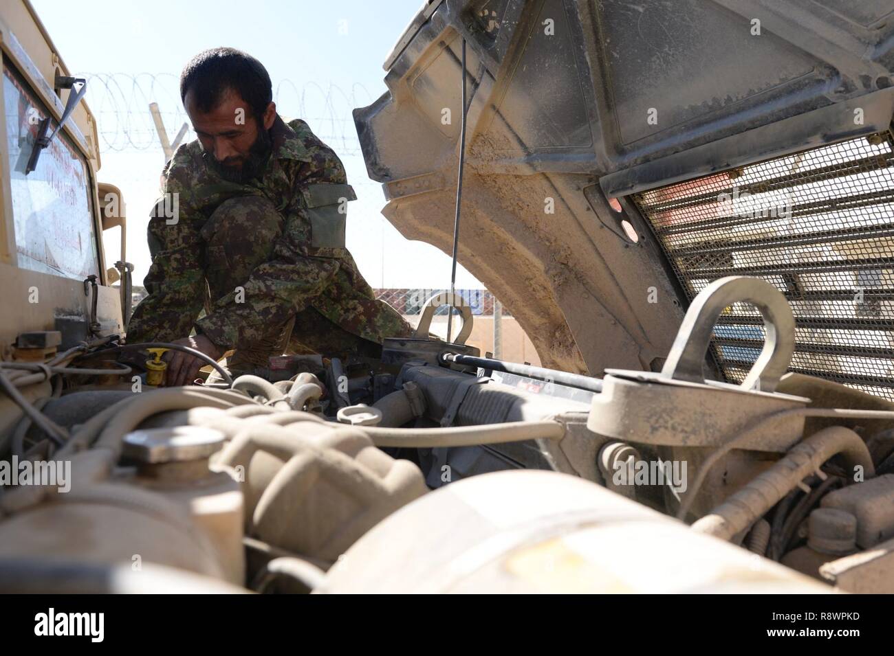 An Afghan National Army 215th Corps mechanic works on a Humvee in ...