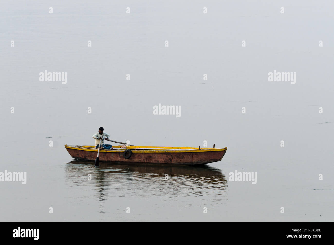 Indian man sailing a wooden boat on the Ganges river, Varanasi, Uttar ...