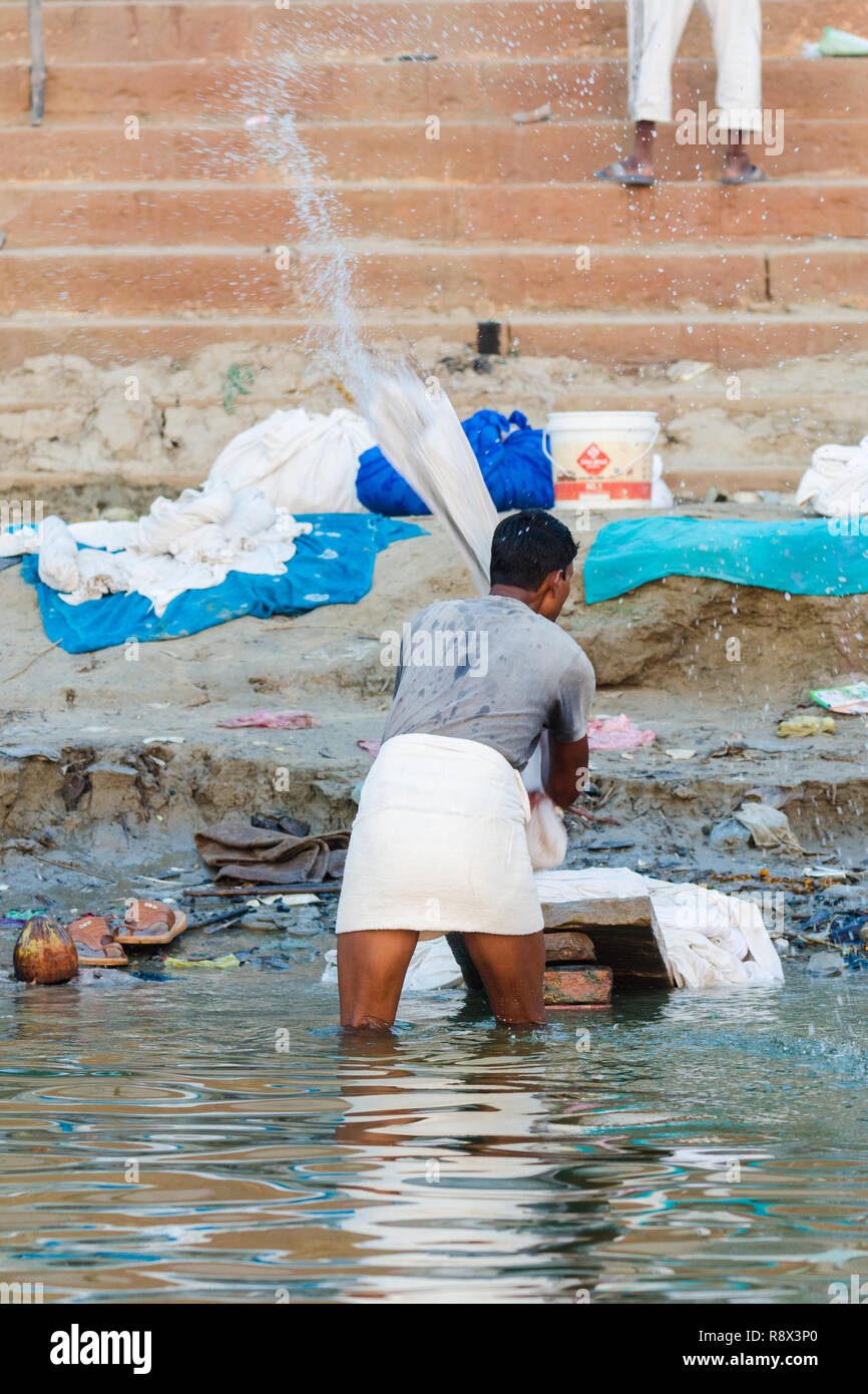 Indian man cleaning clothes in the Ganges river, Varanasi, Uttar ...