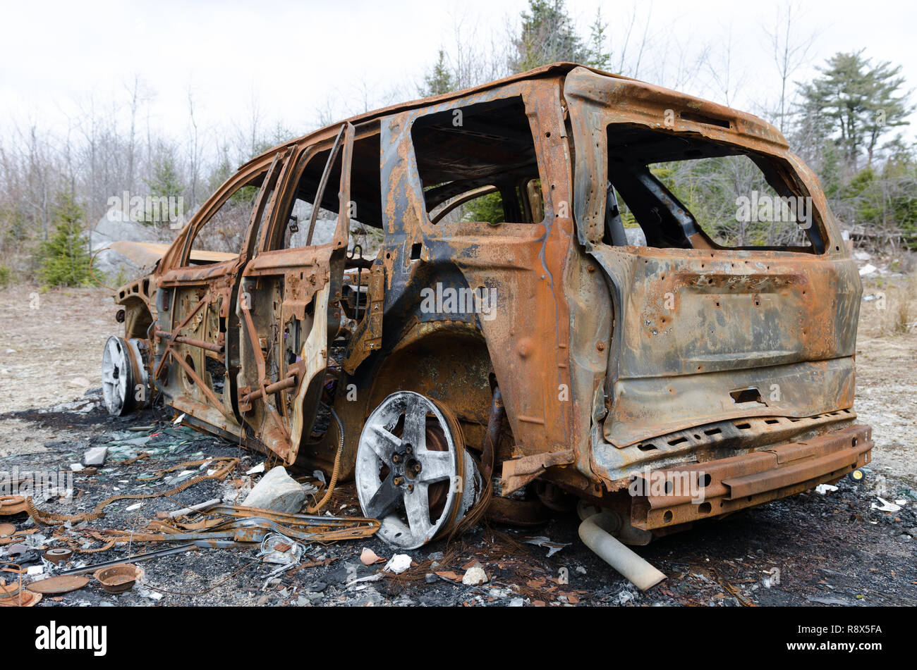 Burnt down rusty vehicle abandoned in the woods with its body falling ...