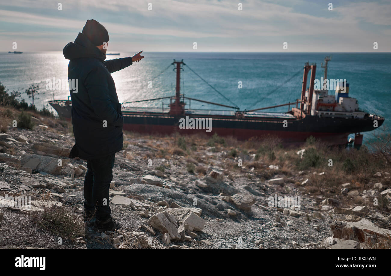 man looking at a cargo ship Stock Photo - Alamy