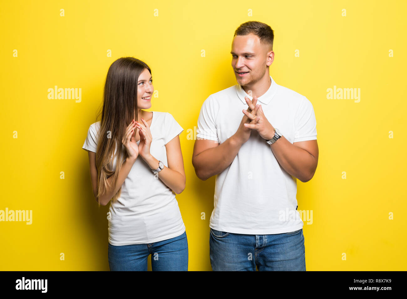 young couple with insidious and grinning faces smile and something ...