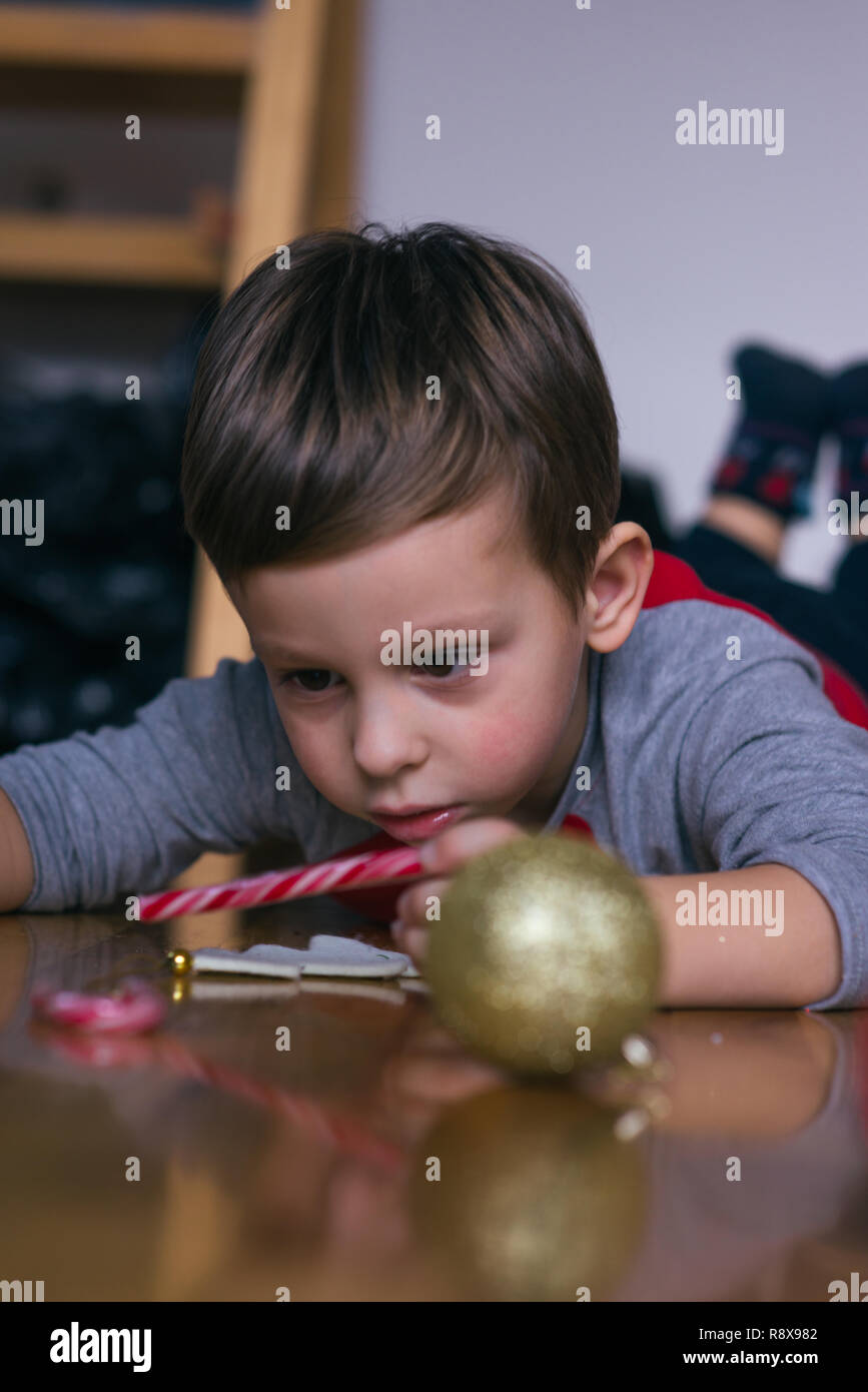 Cute little boy playing with his two favourite candies at Christmas ...