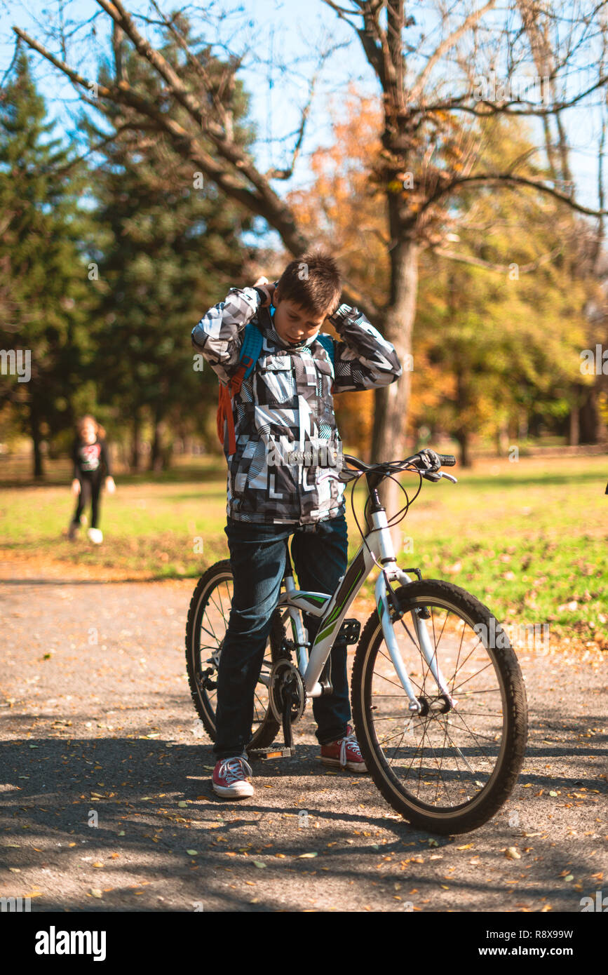 Young happy boy standing with his bike in nature,enjoying the sunny ...