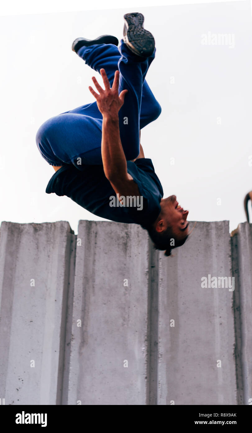 Acrobat man training parkour exercise while jumping backflip obstacles ...