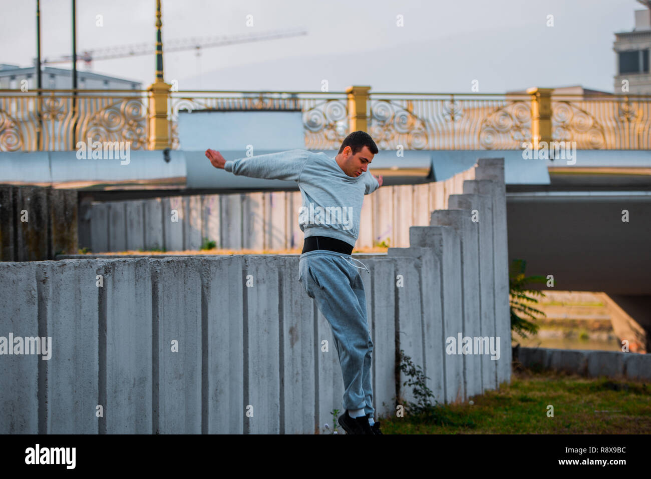 Free runner practicing jumping over concrete obstacles in park Stock ...