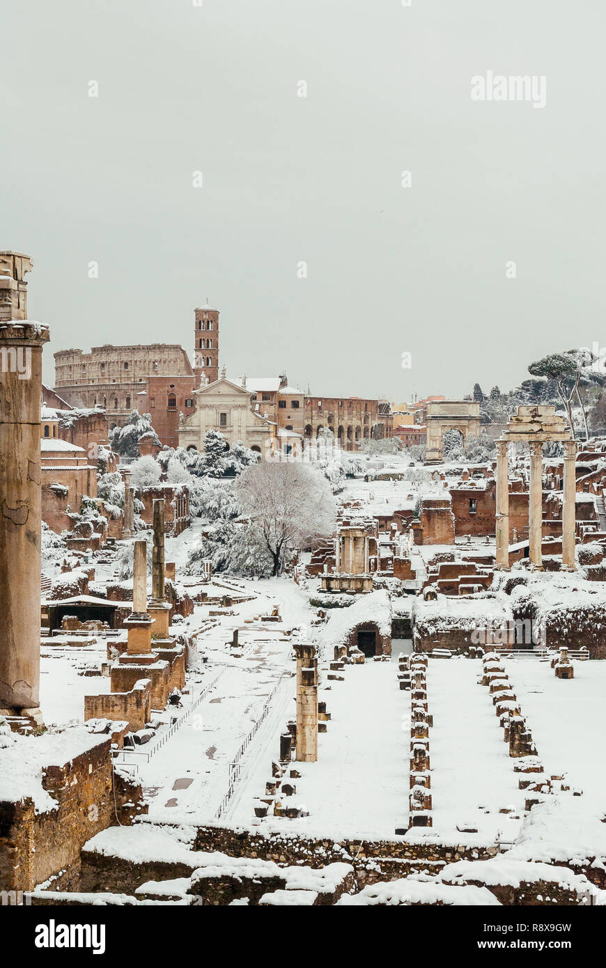 Frozen Rome. View of Roman Forum ancient ruins and Coliseum covered by ...