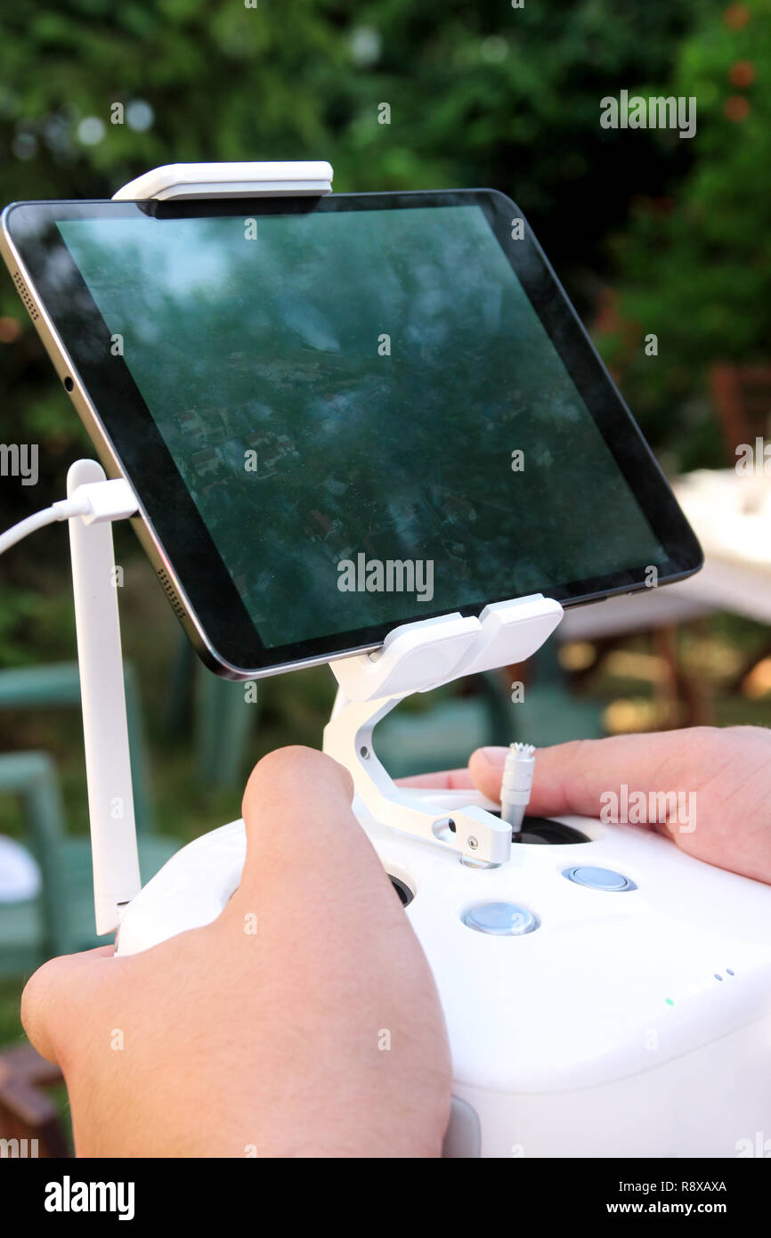 Professional photographer and drone pilot holds remote control panel ...