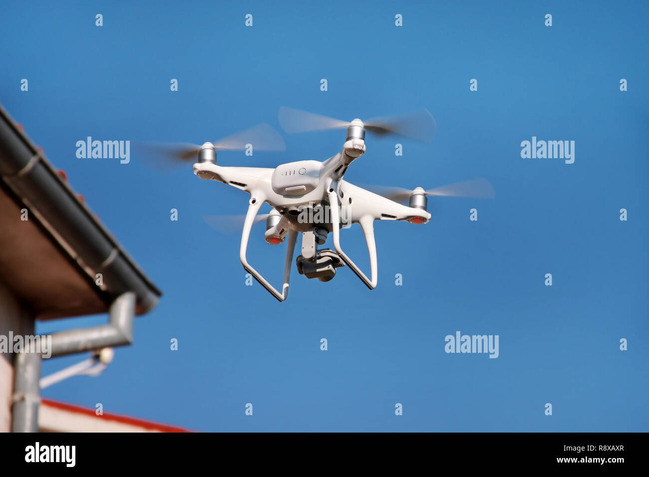 Drone quad copter fly on blue sky in background. Modern drone is flying ...