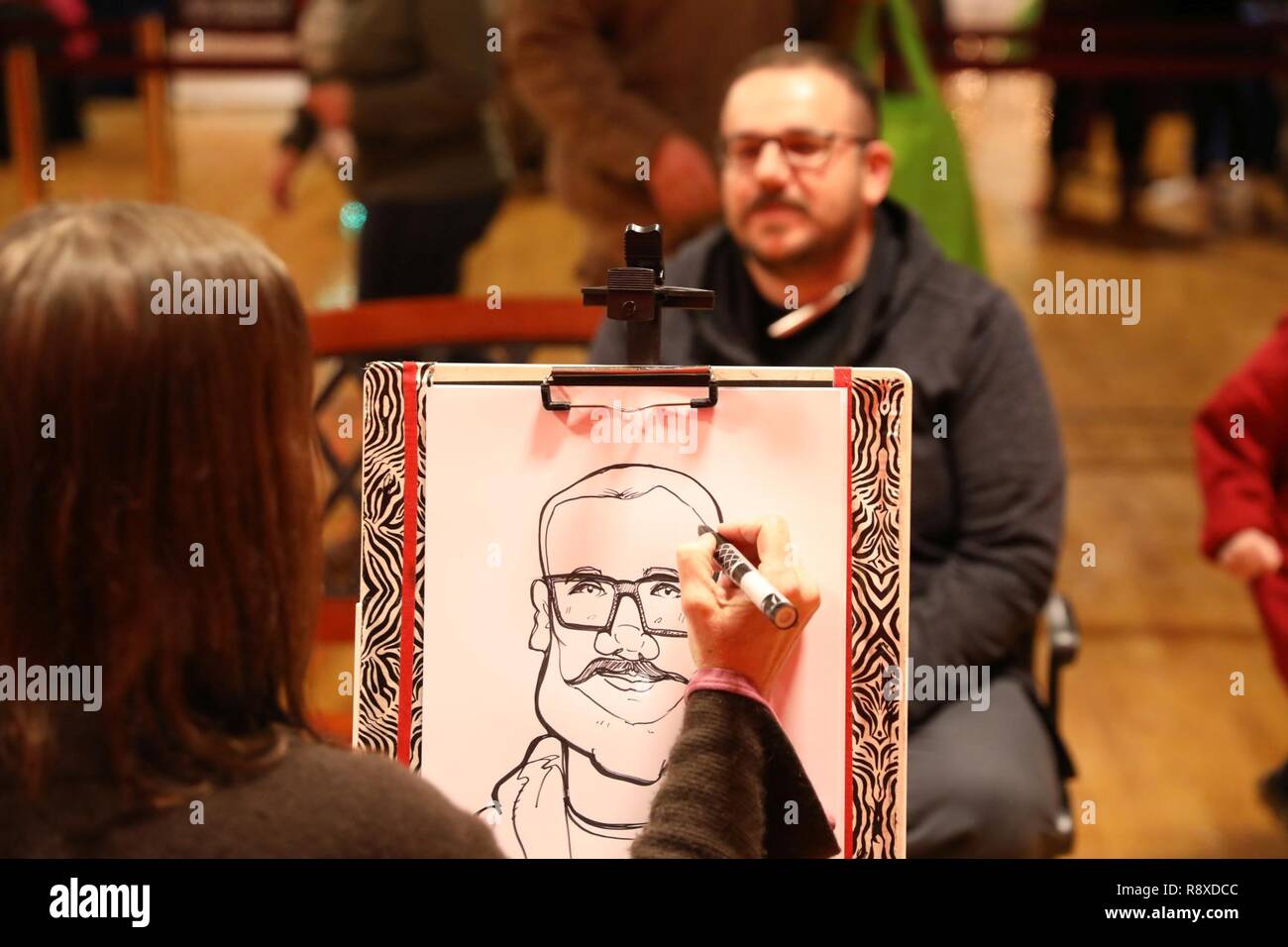A local artist draws a caricature for a guest during the annual Fort ...