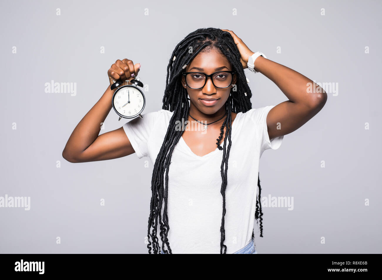 Portrait of shocked young afro american woman holding alarm clock ...