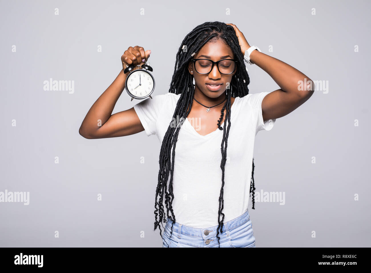 Portrait of shocked young afro american woman holding alarm clock ...