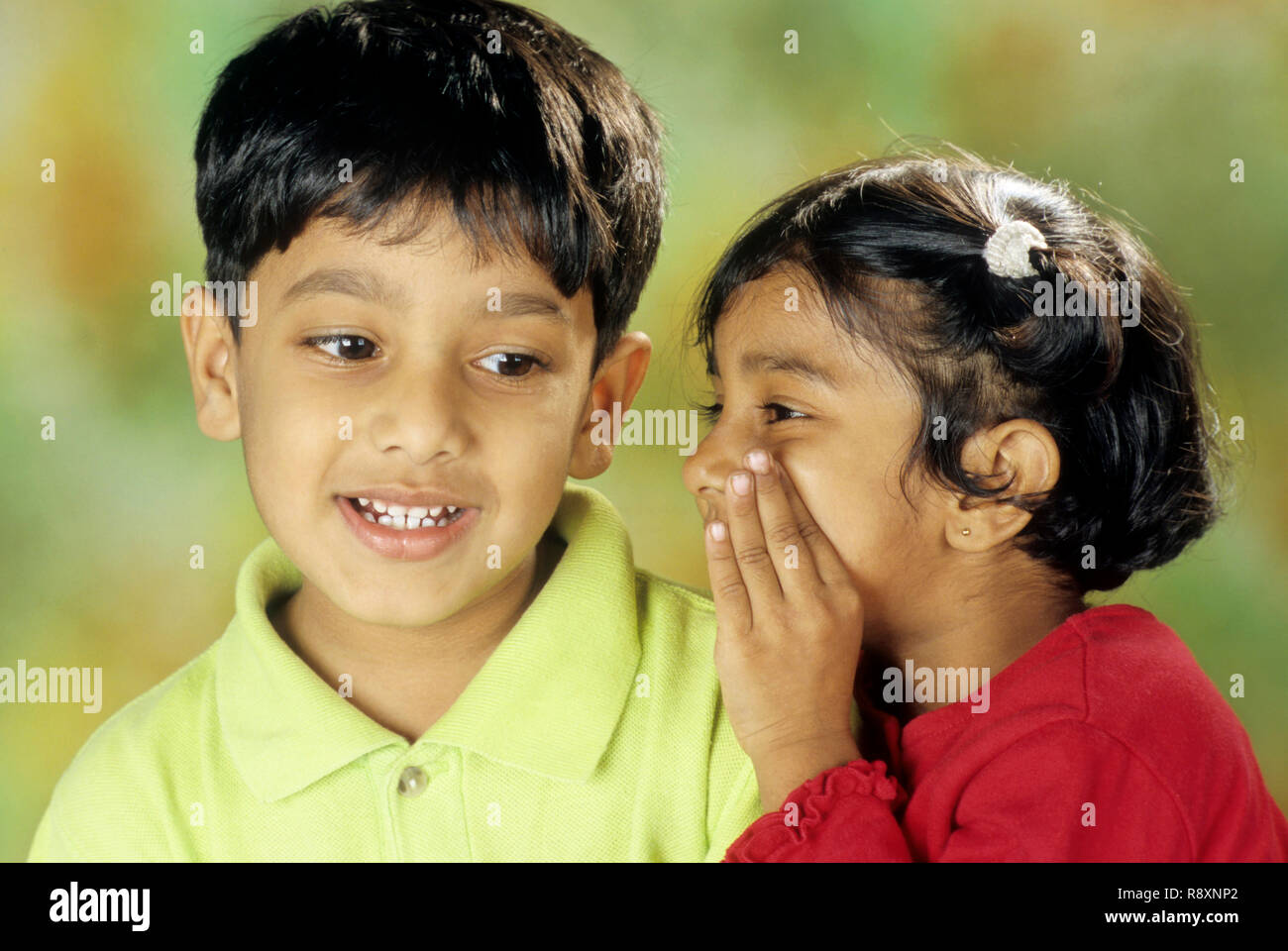 Girl whispering into boys ear hi-res stock photography and images - Alamy