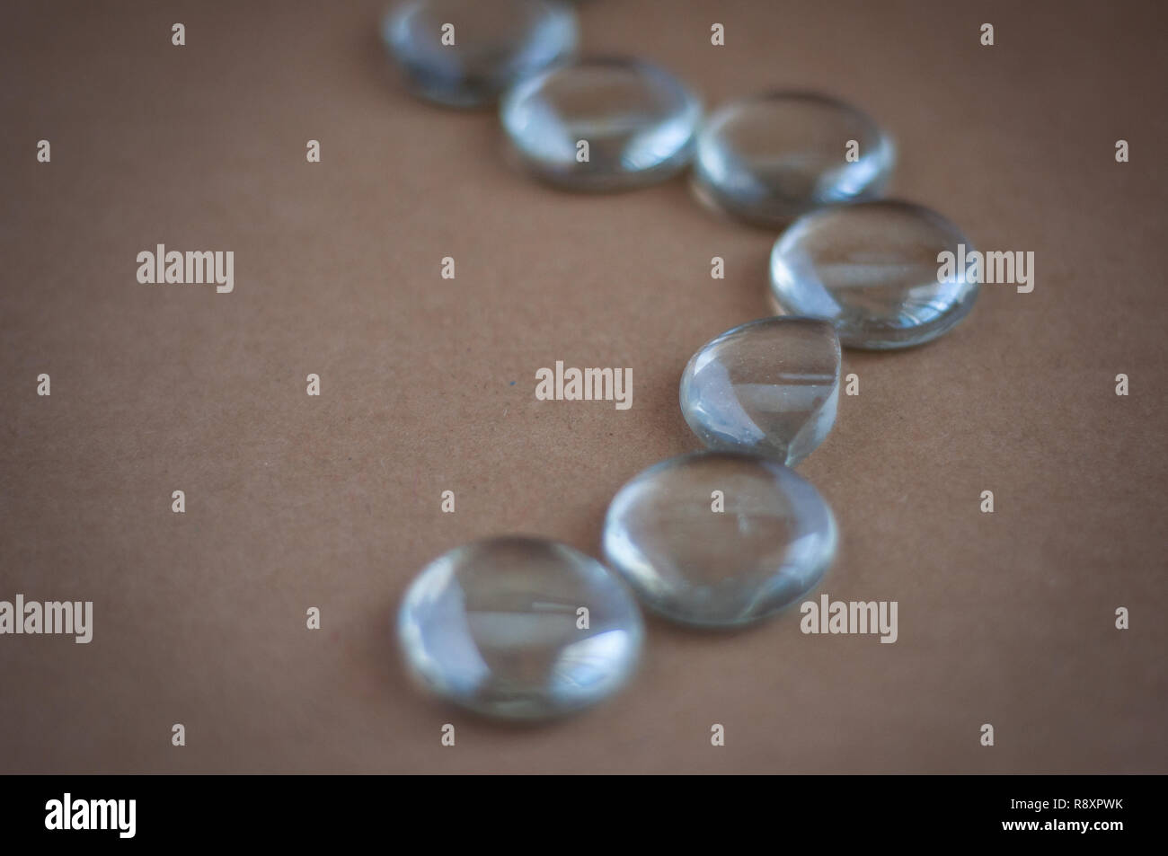 Clear marbles with light reflections on a brown background Stock Photo ...