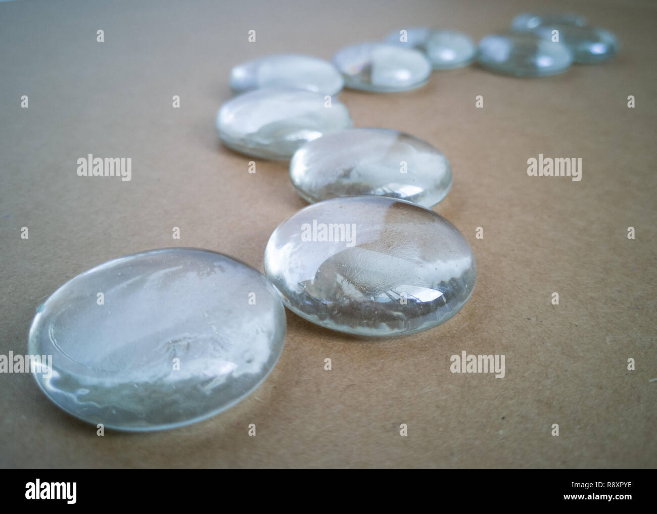 Clear marbles with light reflections on a brown background Stock Photo ...