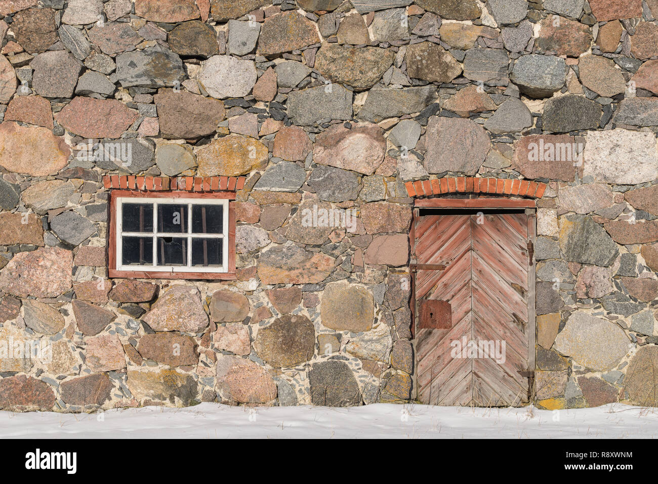 Stone wall texture and windows with red frames, natural background ...
