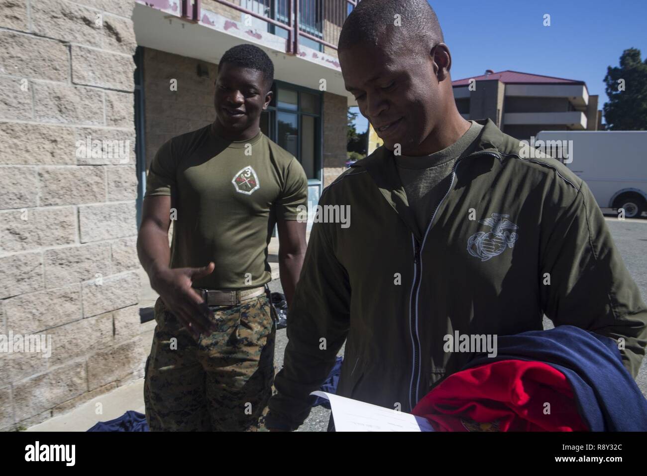 U.S. Marine Corps 1st Sgt. Sean Hyman, right, receives a shirt for the ...