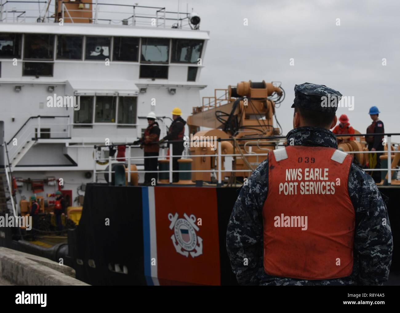 NEW YORK – A U.S. Navy member stand ready to help Coast Guard Cutter Katherine Walker moor up at ...