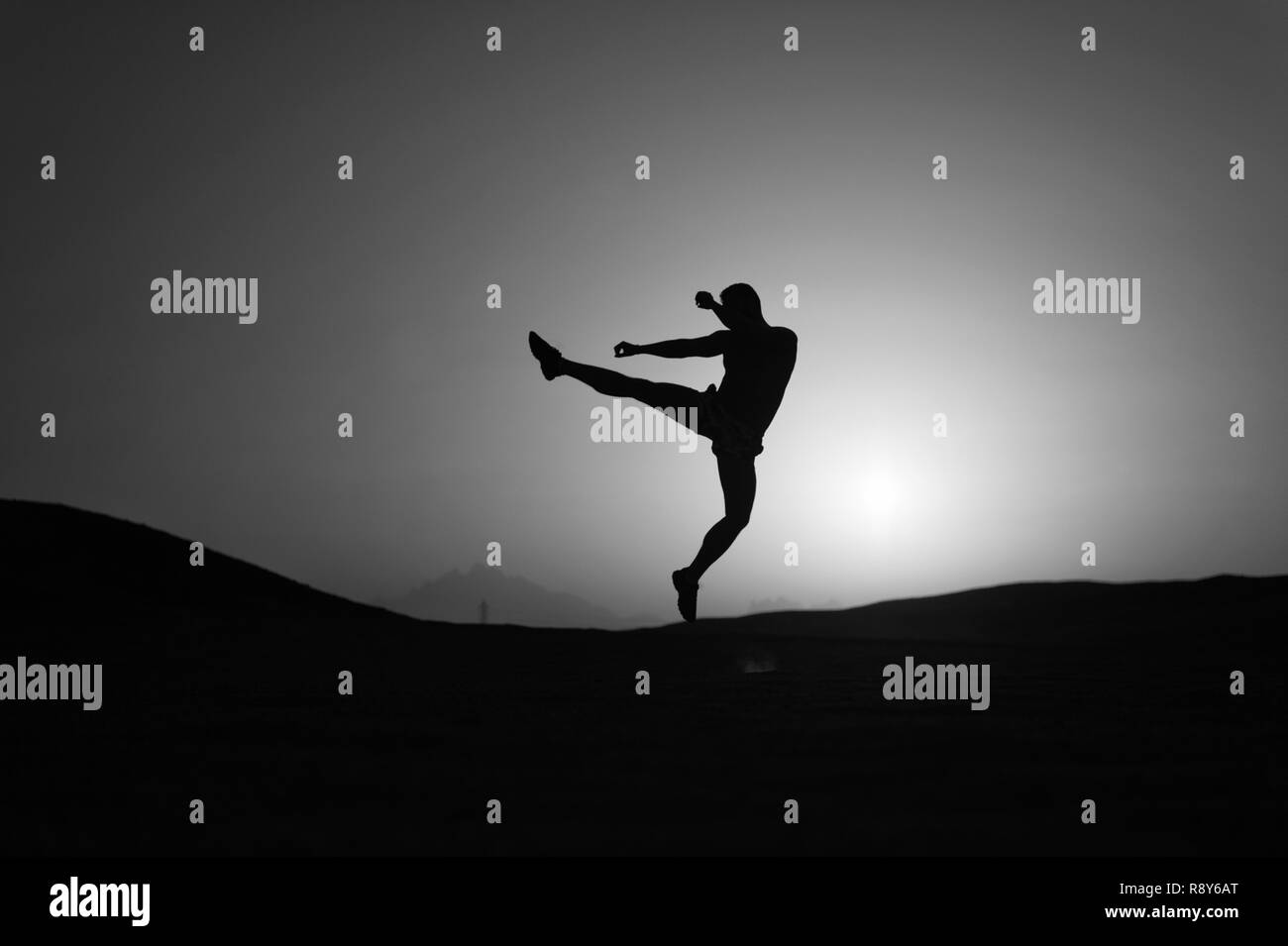 Hit your goal. Silhouette man motion jump in front of sunset sky ...