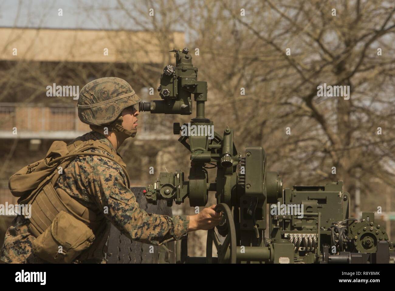 A Marine adjusts the main sight on a M777 howitzer during a gunner and ...