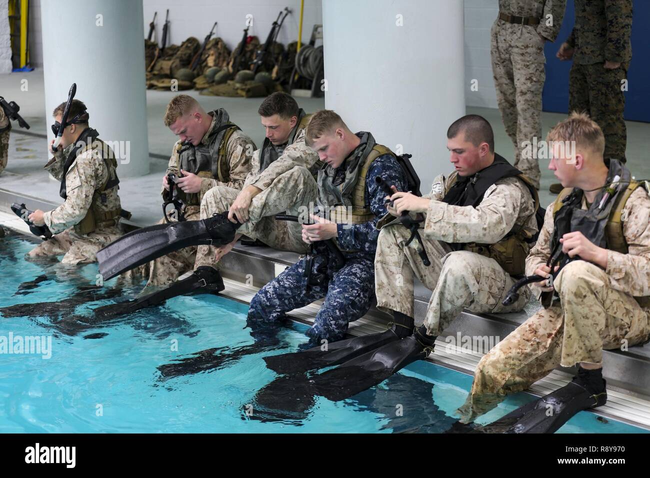 Marines and sailors put on dive gear during a pre-dive class at Camp ...