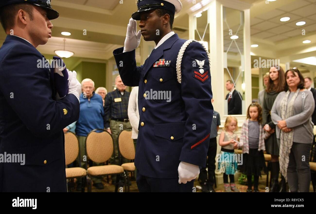 Coast Guard members render honors during a flag ceremony held for the ...