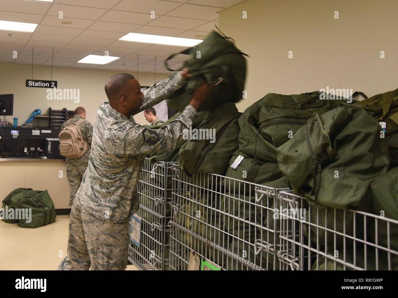 An Airman places a mobility bag into a bin during a training exercise ...