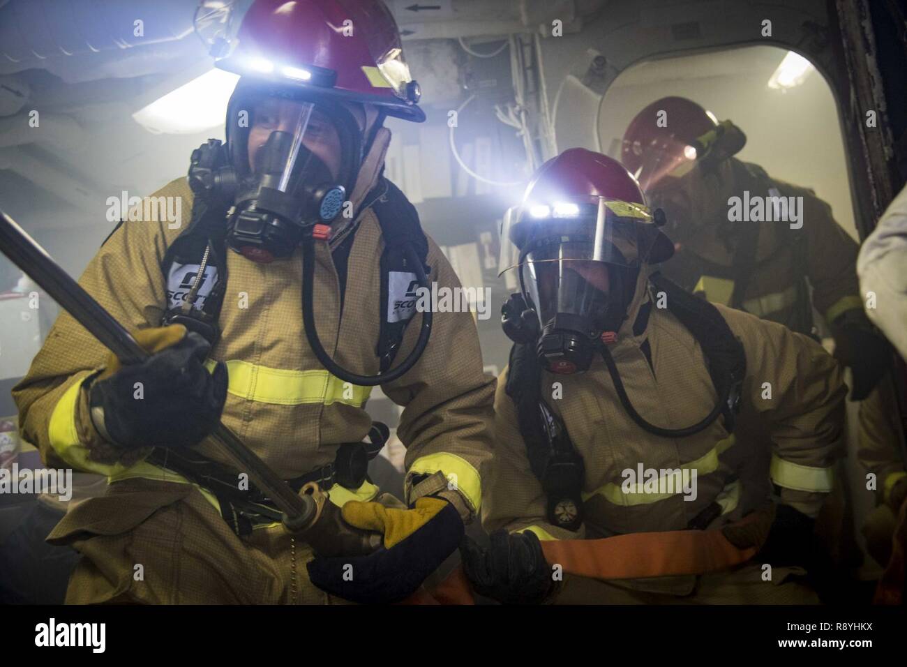Sailors combat a simulated fire during a general quarters drill aboard ...