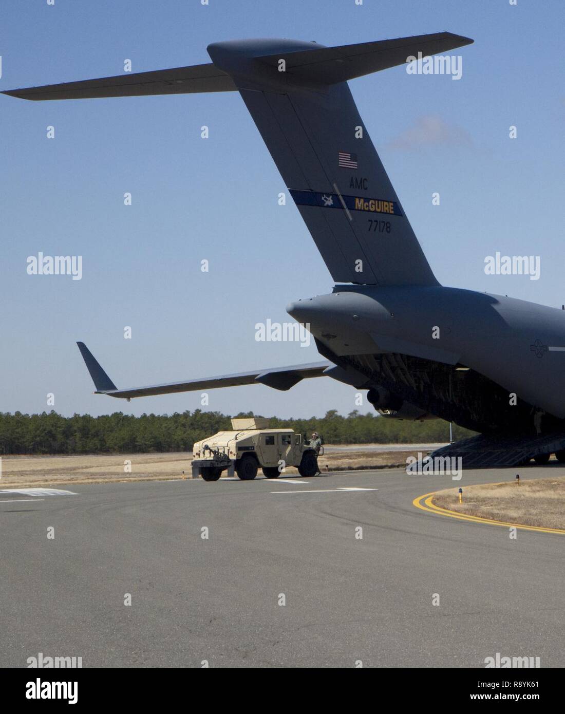 A U.S. Airman ground guides a Humvee as it is offloaded from an Air ...