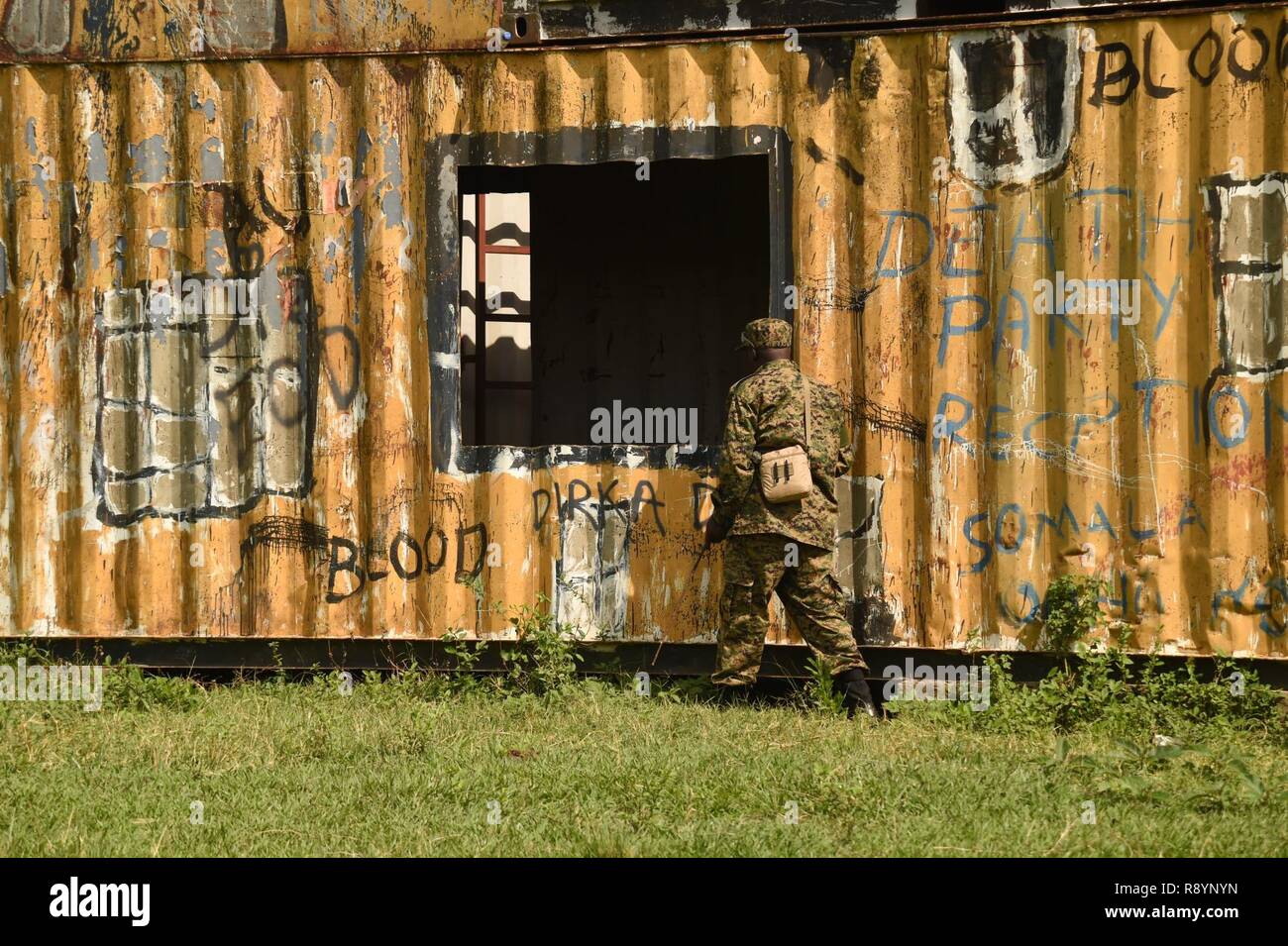 A Uganda People’s Defense Force (UPDF) soldier inspects a building ...