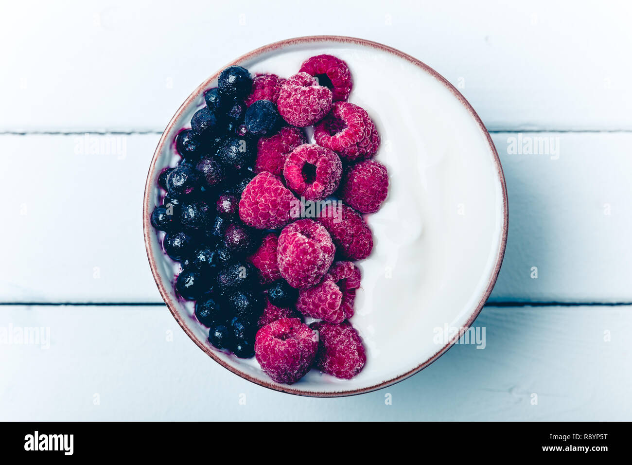 Raspberries and blueberries in a Bowl. Healthy breakfast concept with ...