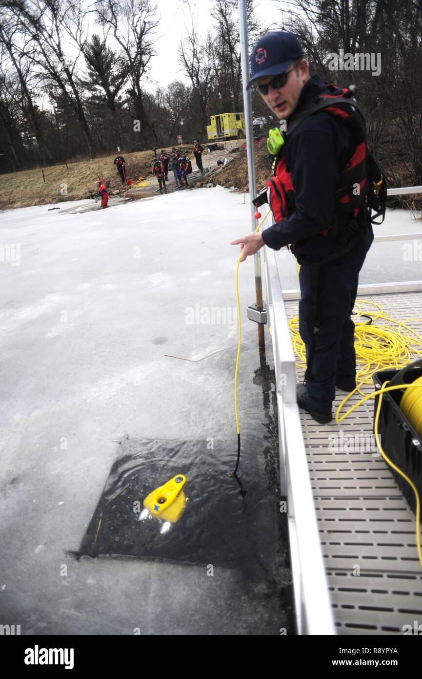 A member of the Fort McCoy Fire Department dive team deploys a VideoRay ...
