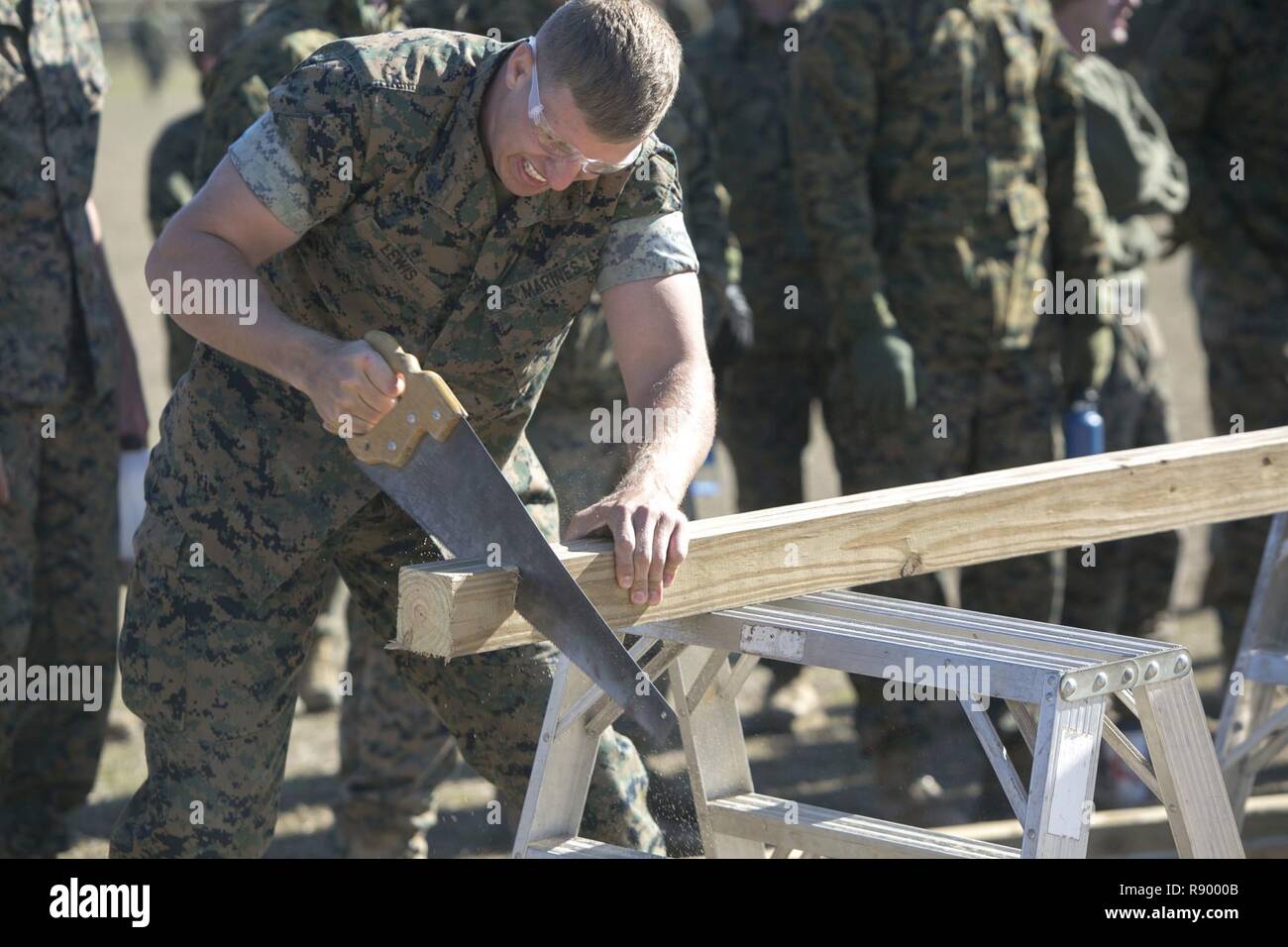 A Marine saws a piece of wood during a relay portion of the Engineer ...