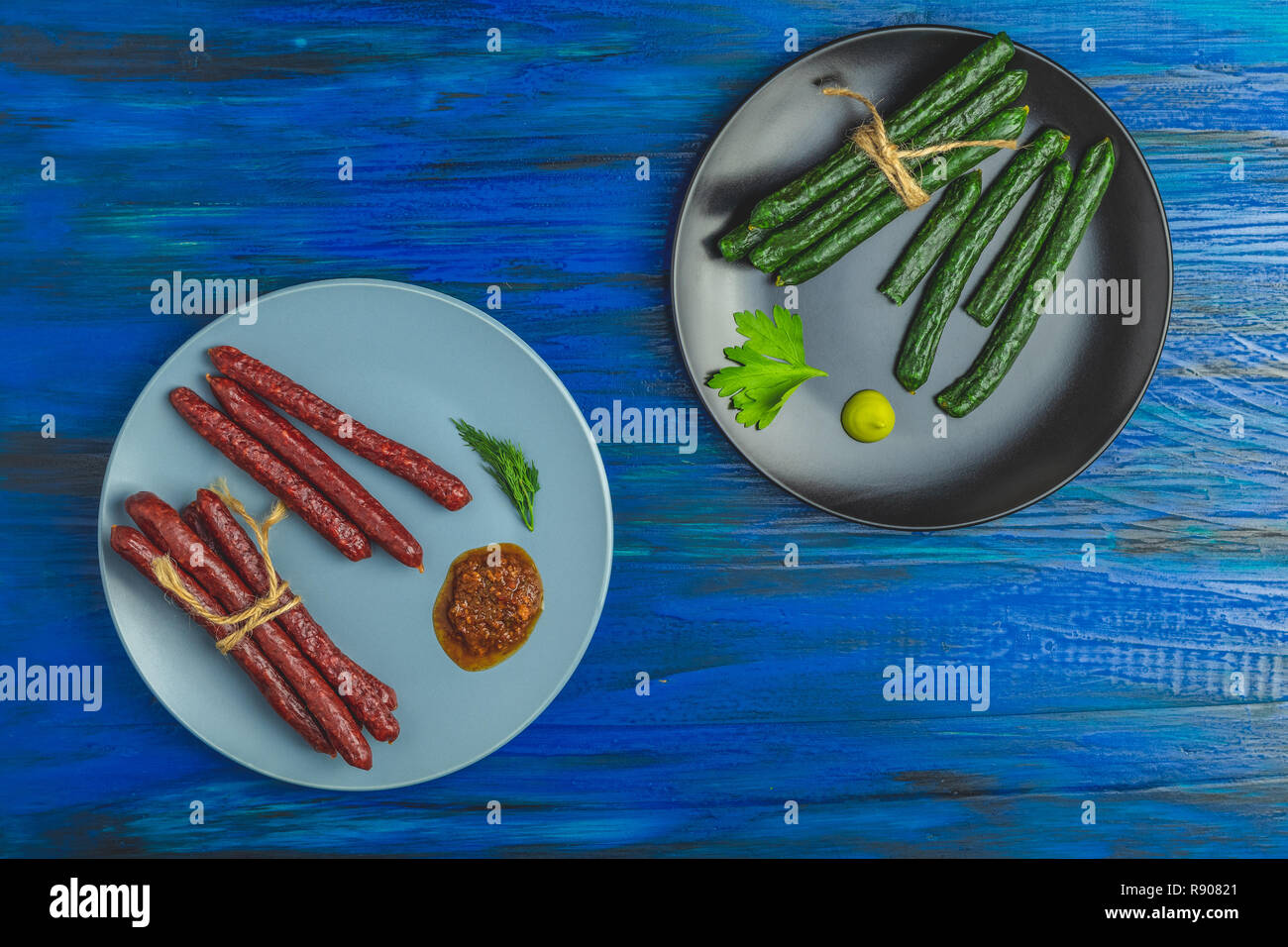 Kabanosy, sausages green with wasabi made of pork in black plate and ...