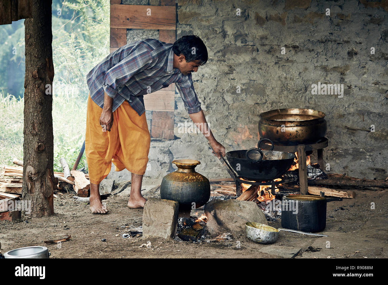 NAGGAR, INDIA - JULY 17: Cooking indian. Hindu man preparing food for a ...