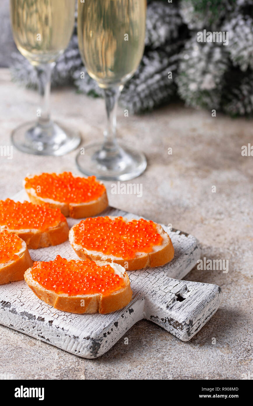 Toasts with red salmon caviar and champagne Stock Photo - Alamy